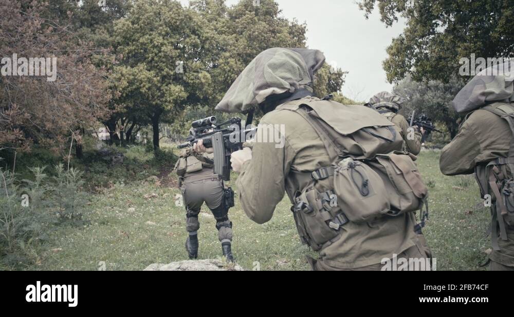 Squad of fully armed commando soldiers during combat in a forest ...