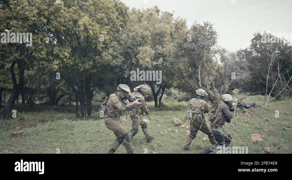 Squad of fully armed commando soldiers during combat in a forest ...