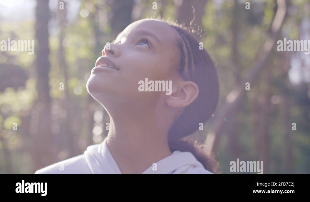 Beautiful young child looking around a forest in the sunlight, in slow ...