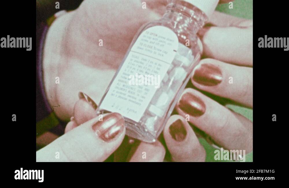 1970s: Woman reads label on back of bottle, opens bottle, removes pill ...
