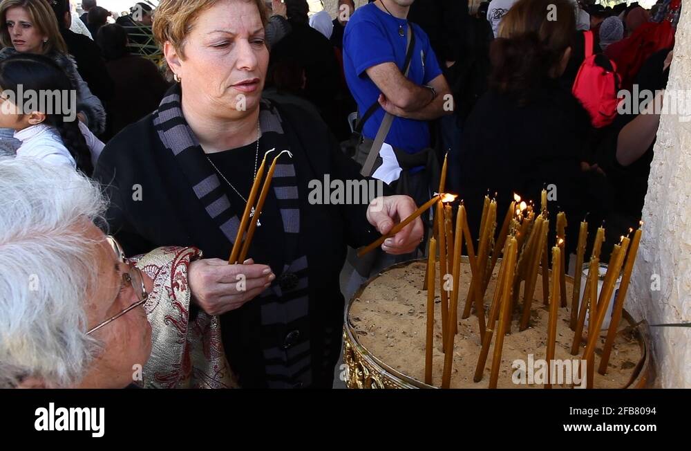 Pilgrim light candles at baptismal site in the Jordan River Holy Land ...