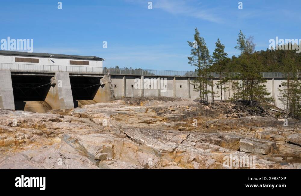 Water hold back dam in Uldalsana lake with pine trees and dry rocky ...