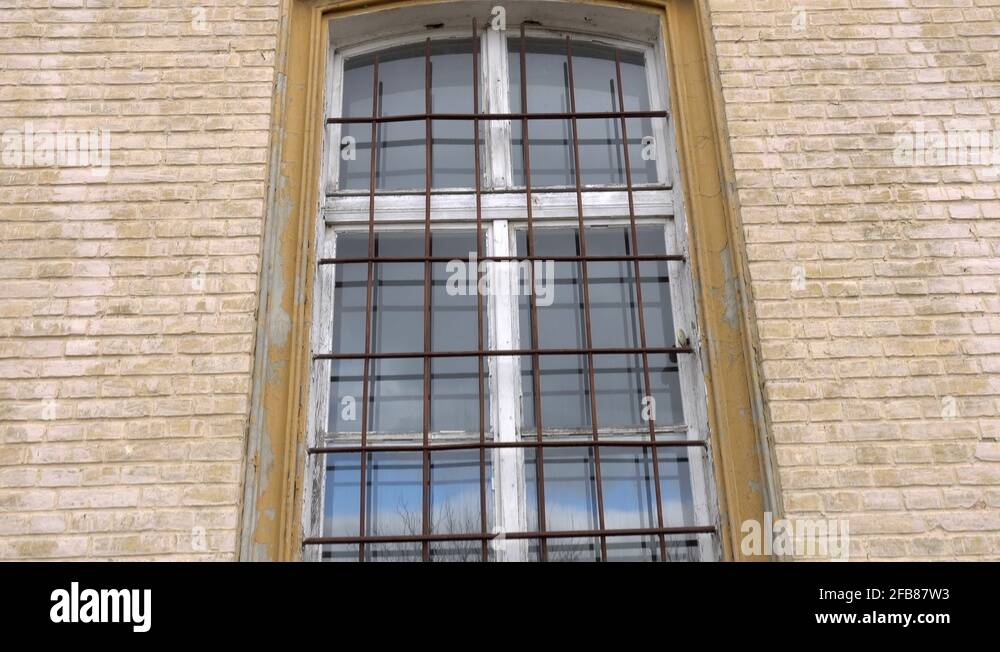 Tilt shot of big wooden window with steel bars and basement window ...