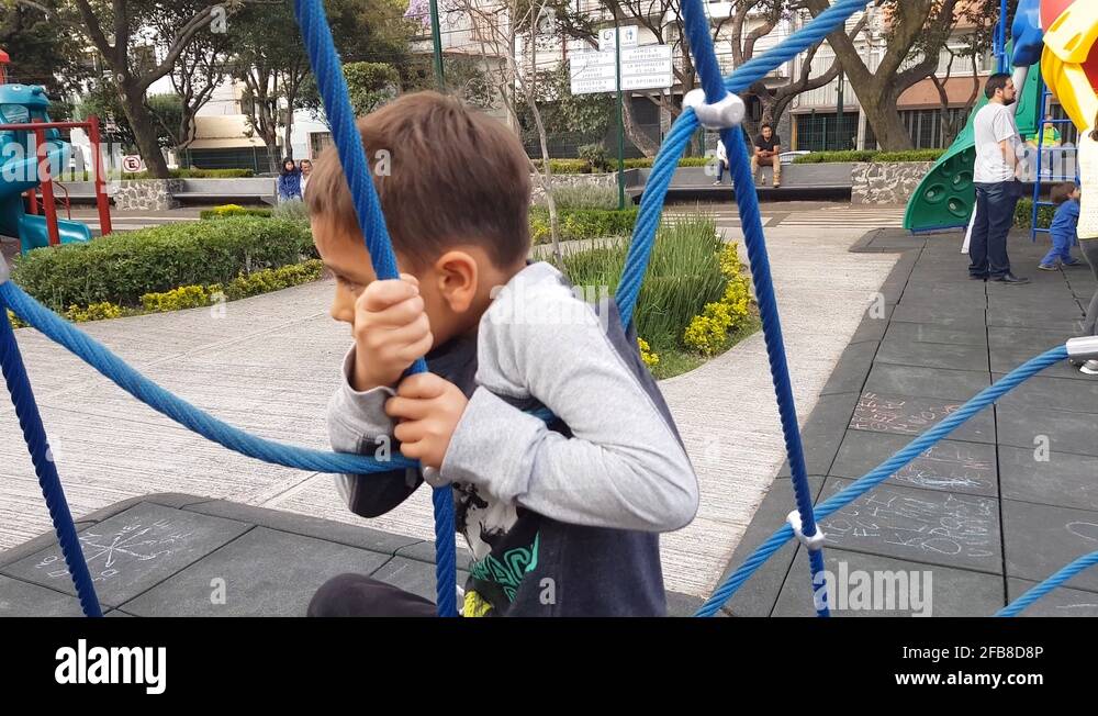 Boy climbing down the ropes at a playground Stock Video Footage - Alamy