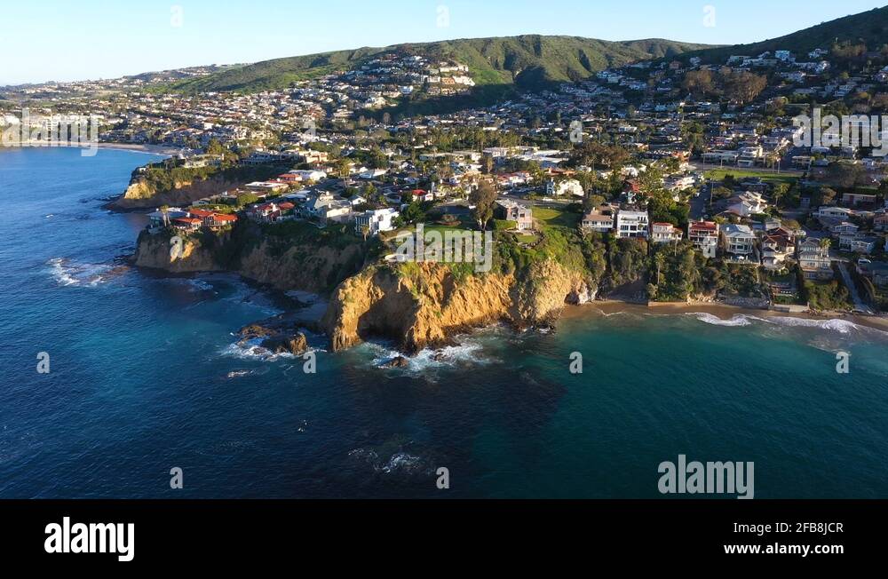 Drone aerialing sideways of Laguna Beach, cliffs and hills, with luxury ...