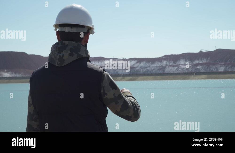 Salt quarries, back view of man engineer studying the area and use a ...