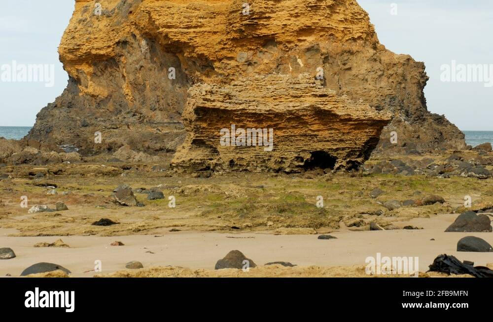 Limestone stack located at an Australian coastal beach. LOW ANGLE. TILT ...