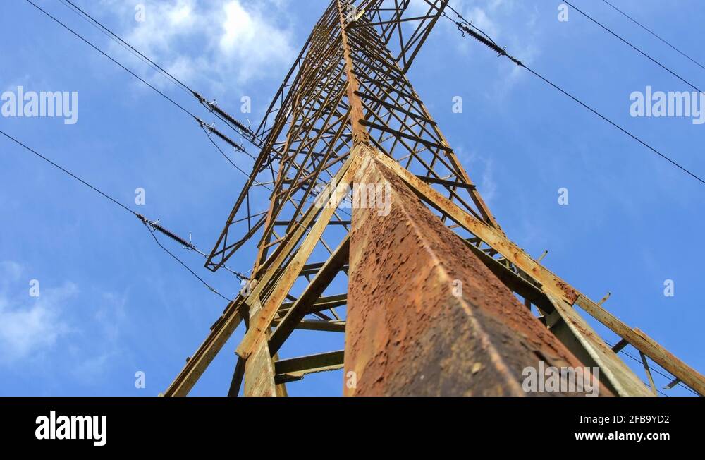 Old Rusty Transmission Tower and High Voltage Power Lines on Blue Sky ...