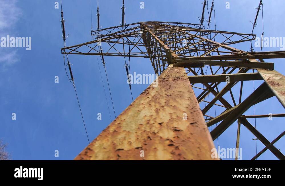Old Rusty Transmission Tower and High Voltage Power Lines on Blue Sky ...