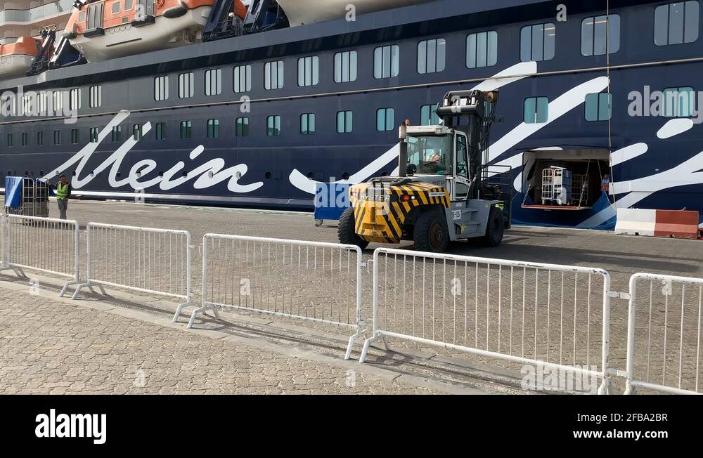 Men with carts and forklift unloading and loading cruise ship at Port ...