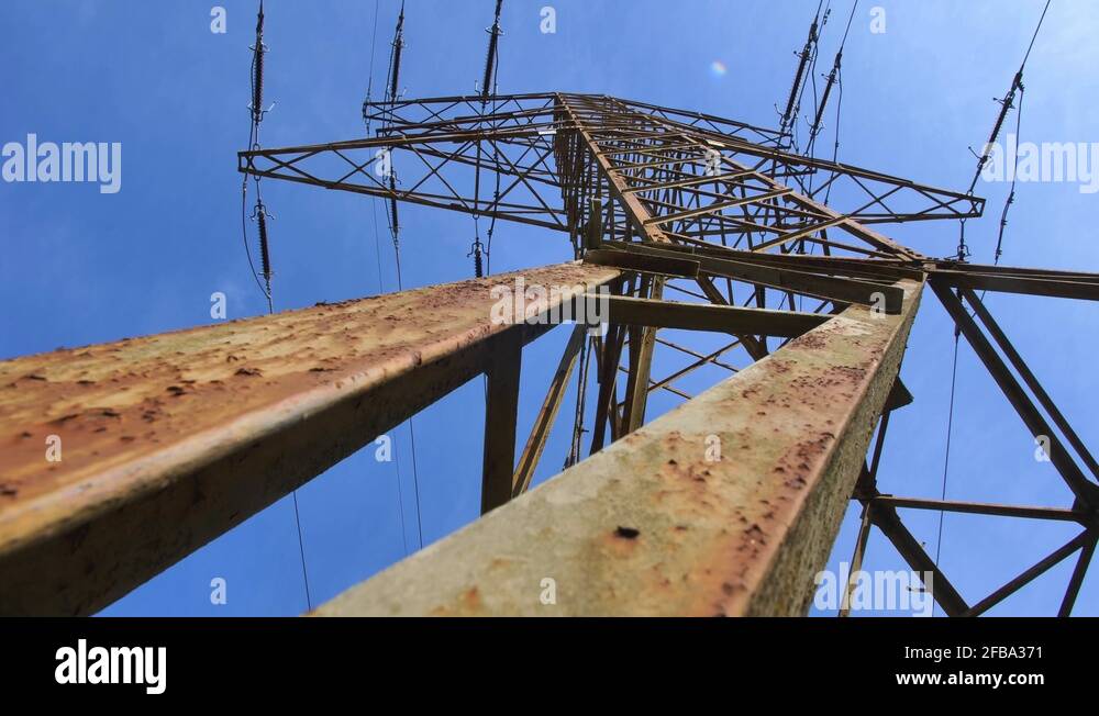 Old Rusty Transmission Tower and High Voltage Power Lines on Blue Sky ...