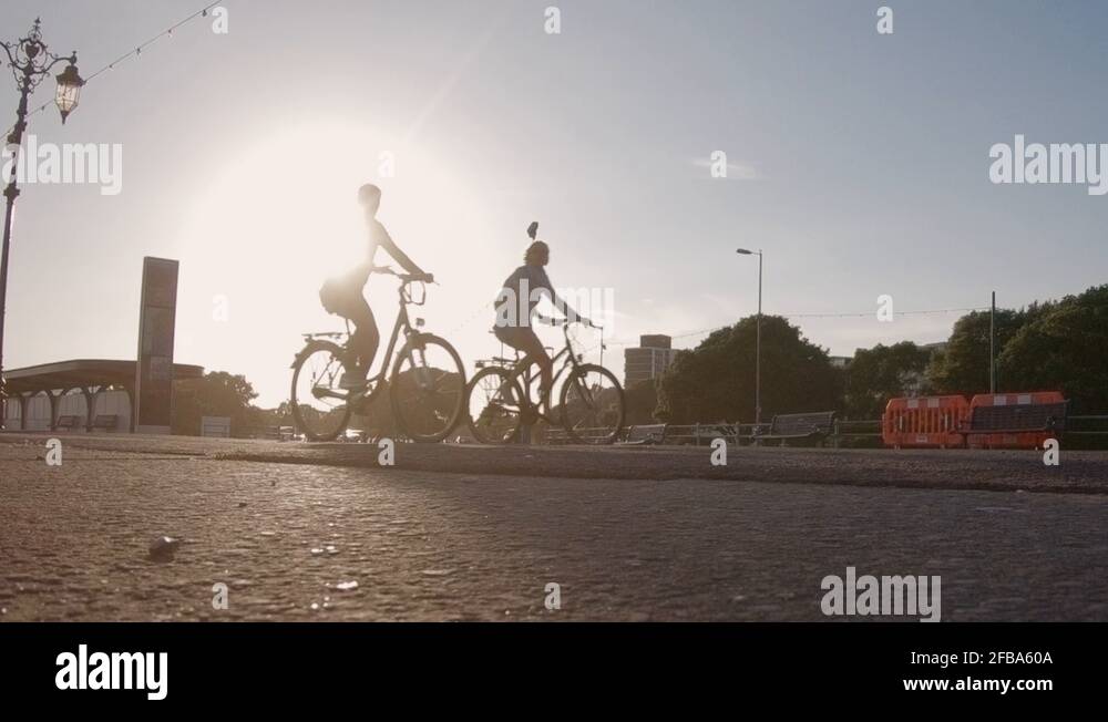 Wide angle and low level pan from left to right as cyclists ride along ...