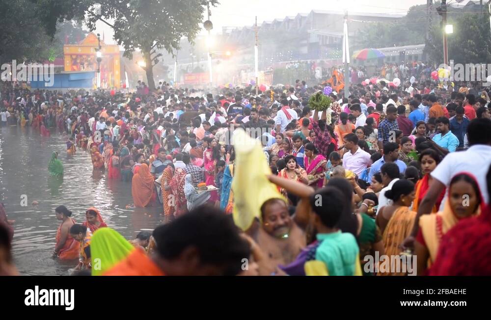 Huge crowd of Hindu Indian people gathered around river for worship of ...
