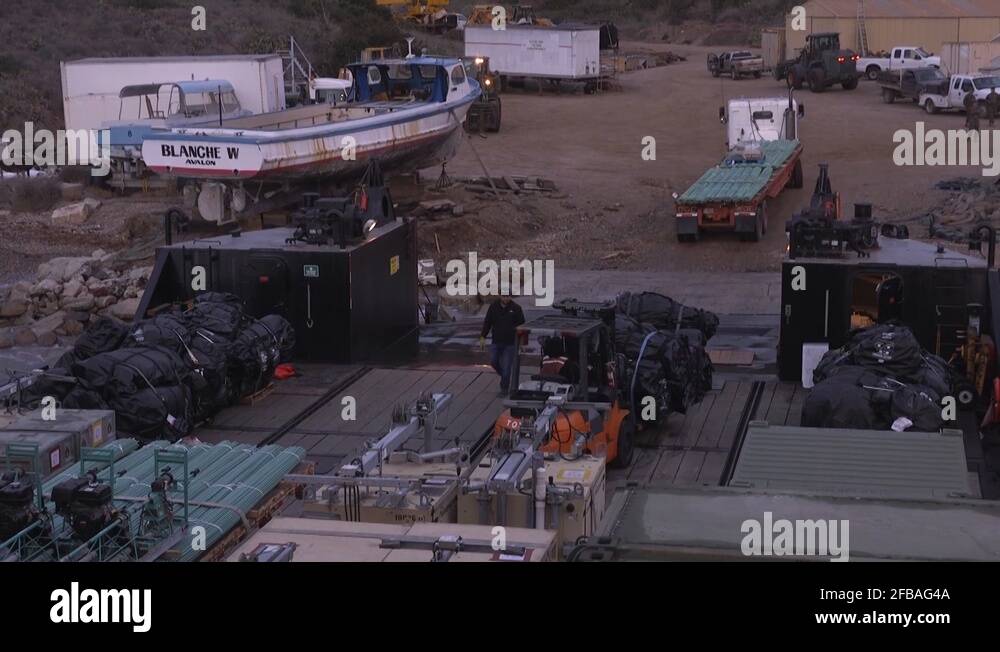 Marines load and embark heavy equipment, vehicles and supplies off a ...