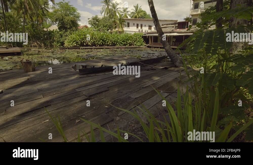 Static view across wood panel platform overlooking still, calm pond ...