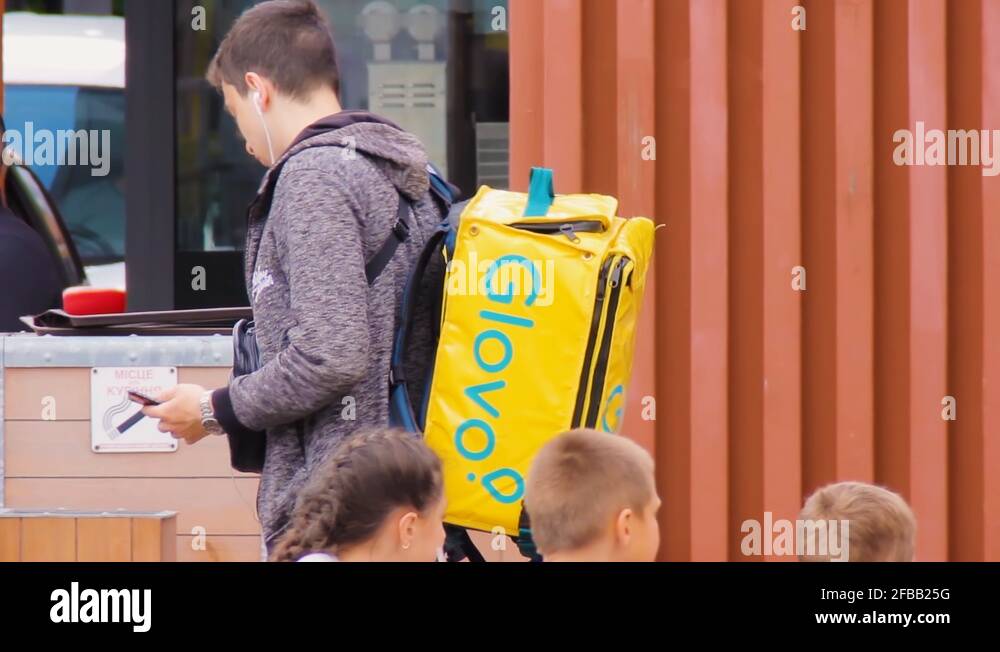 Glover with a yellow backpack with Glovo! logo is arrived Stock Video ...