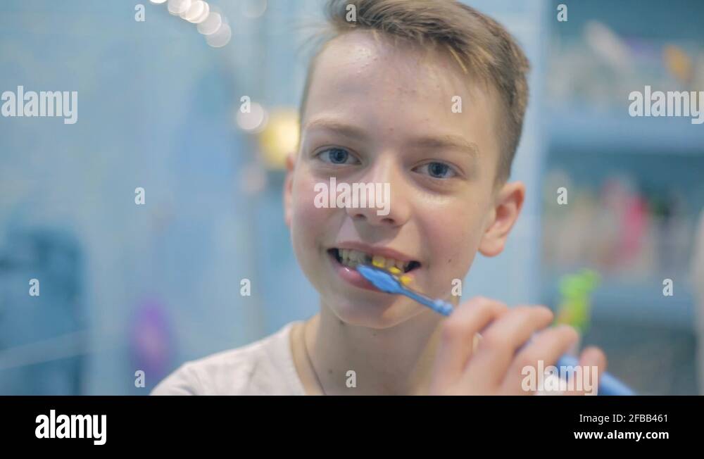teen boy brushing his teeth in the bathroom Stock Video Footage - Alamy