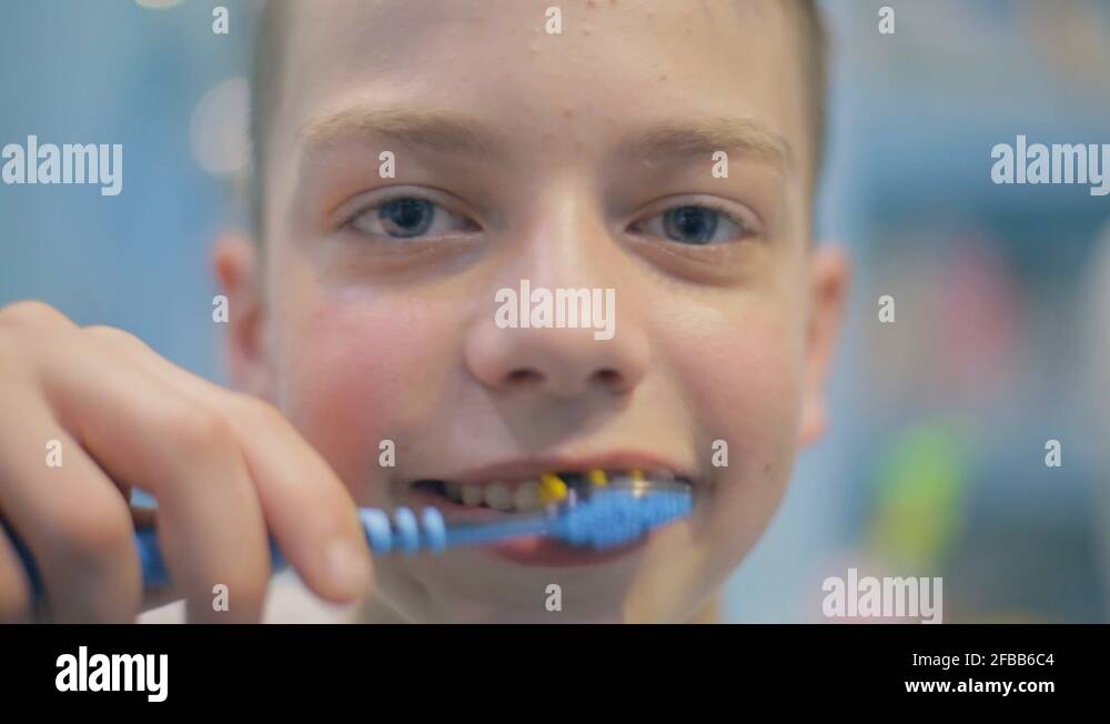 teen boy brushing his teeth in the bathroom Stock Video Footage - Alamy