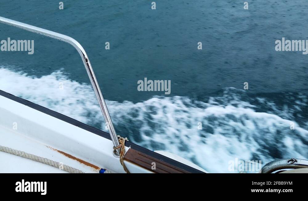 POV over side of boats deck to splashing foamy water below. Fastement ...