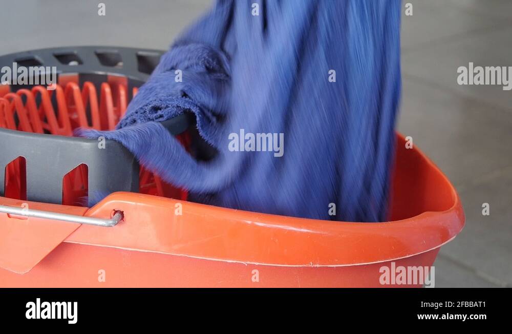 Close-up side view of a mop bucket as the wet mop is wrung out in Stock ...