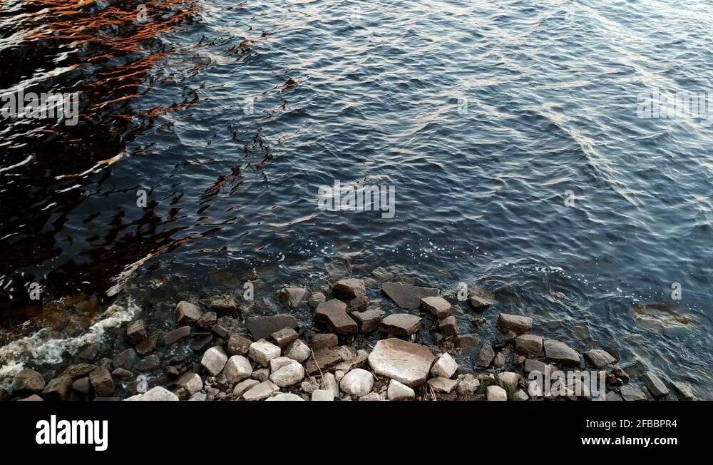 Daugava river bank with water stream patterns of light reflection crash ...