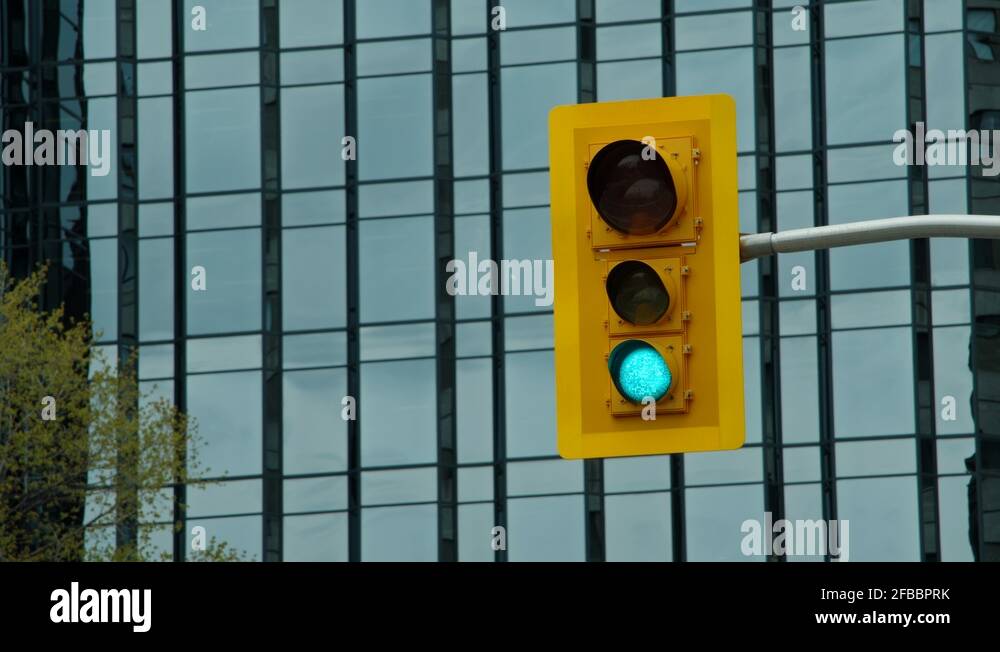 Traffic light in front of modern glass window downtown office building ...