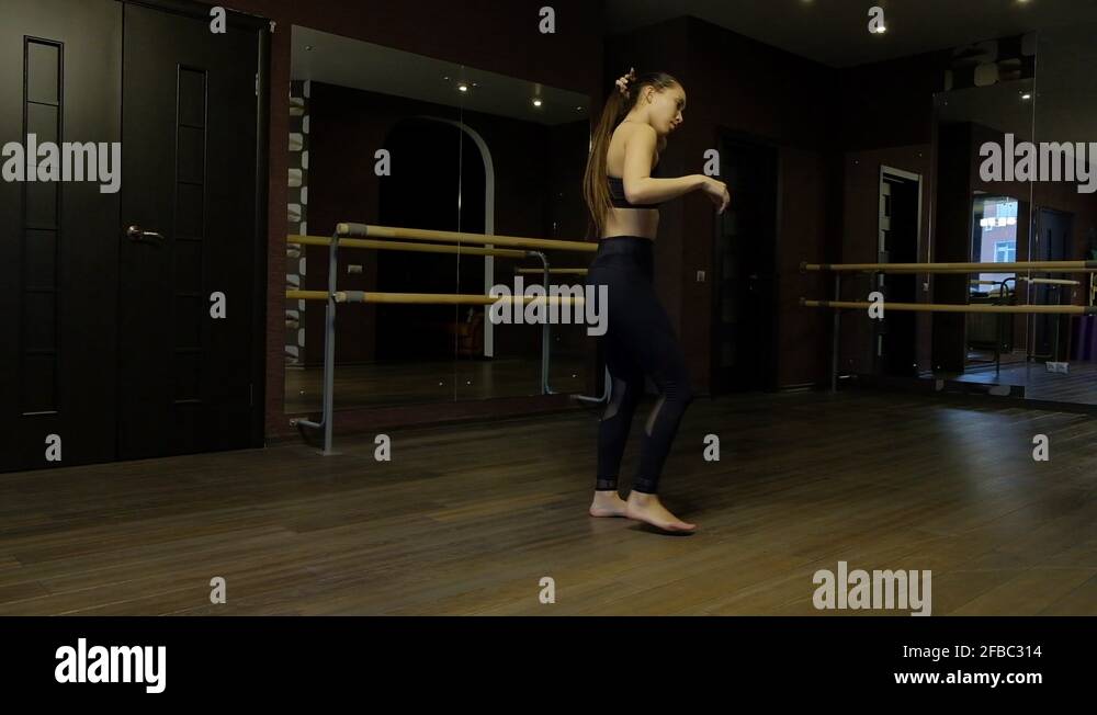 girl dancer with ponytail in black tights demonstrates body flexibility ...