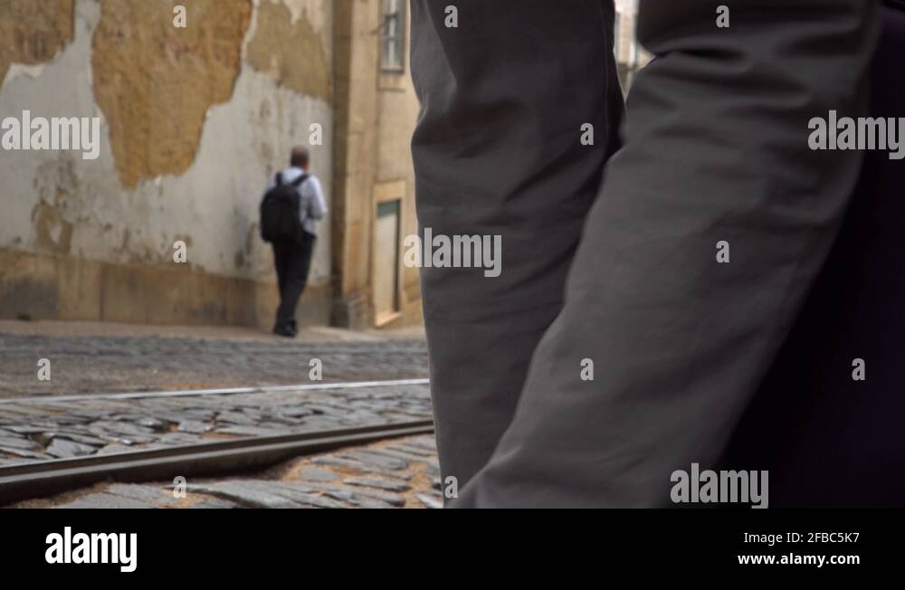 Low perspective shot looking down Alfama district narrow cobbled slope ...