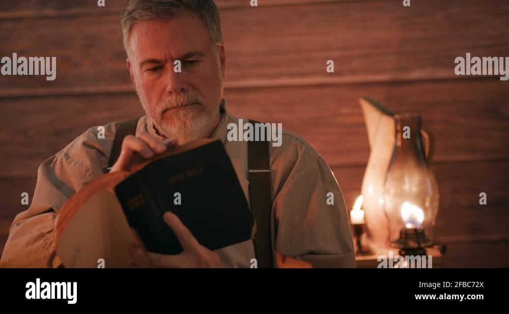 old west pioneer man reading the bible in his cabin Stock Video Footage ...