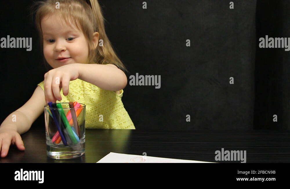 Little girl chooses a red pencil while drawing Stock Video Footage - Alamy