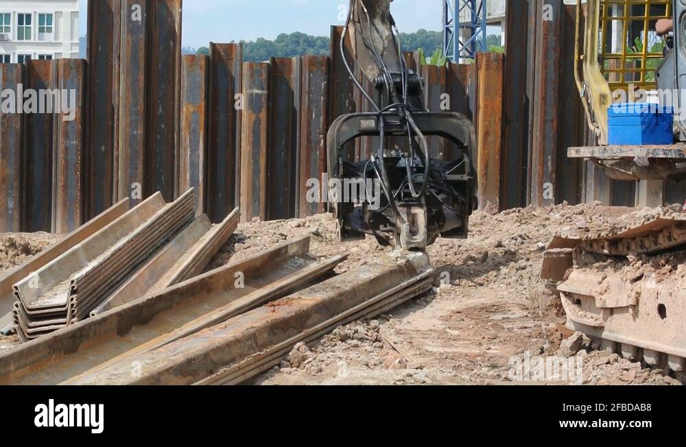 Heavy machinery installing temporary sheet pile cofferdam retaining ...