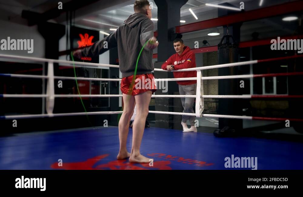 Boxer Jumping the Rope Training with Coach Instructor with Stopwatch in ...