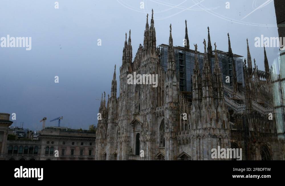 The famous Duomo in milan seen through a glass window from the front ...