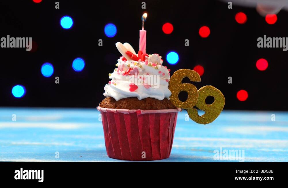 Delicious birthday cupcake with burning candle and number 69 on ...
