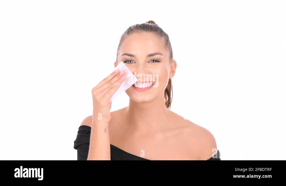 The concept of beauty. A beautiful girl is wiping her face with a ...