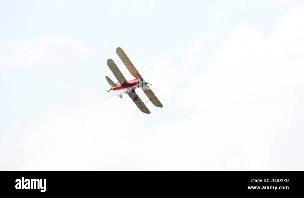 Vintage open cockpit biplane in flight head on view, home built light ...