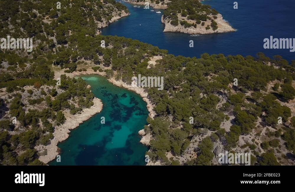 Wide, aerial clip over the scenic beaches of Calanques de Port Pin ...