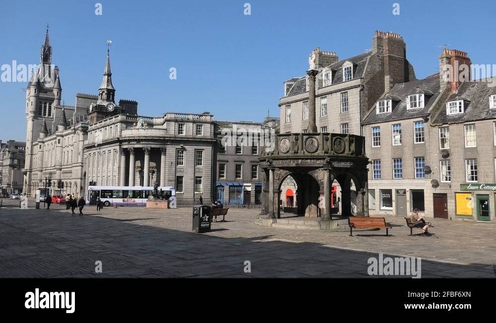 Mercat Cross in The Castlegate Aberdeen with traffic and man sitting on ...