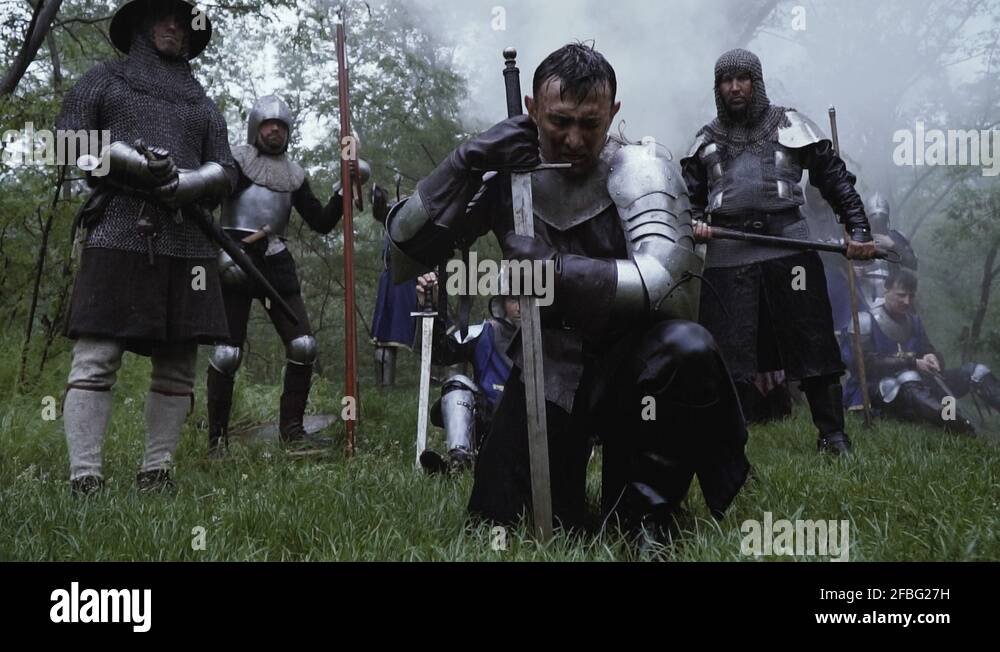 Medieval soldiers are ready for the battle in the forest under rain ...