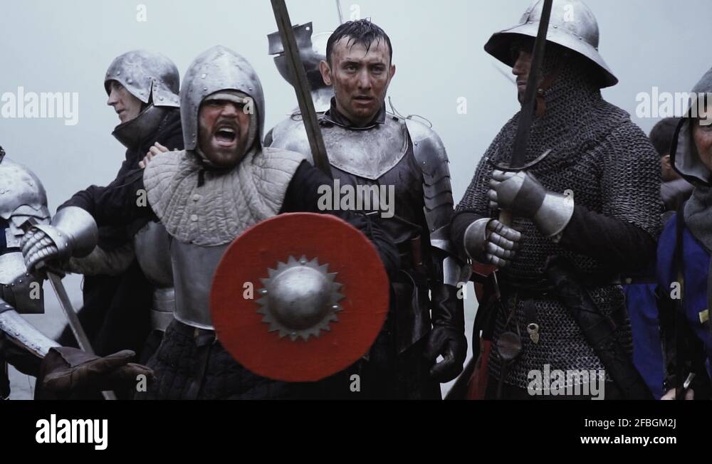 Medieval soldiers with shields and swords are standing on the smoky ...