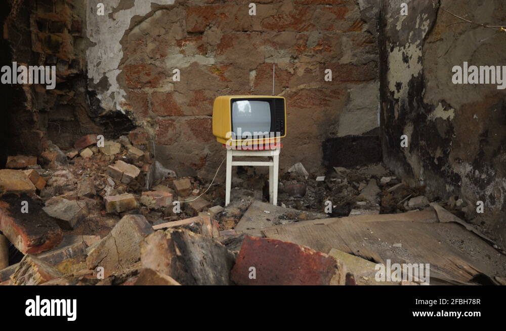 Retro TV with glitch television screen on stool in destroyed house ...