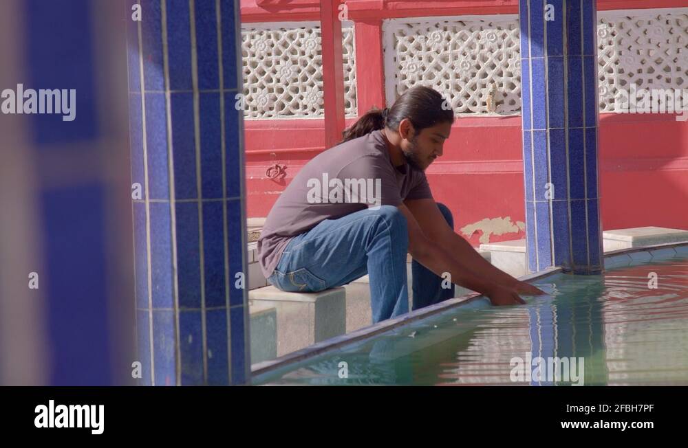 Young man does ablution with water in a mosque camera pans away ...