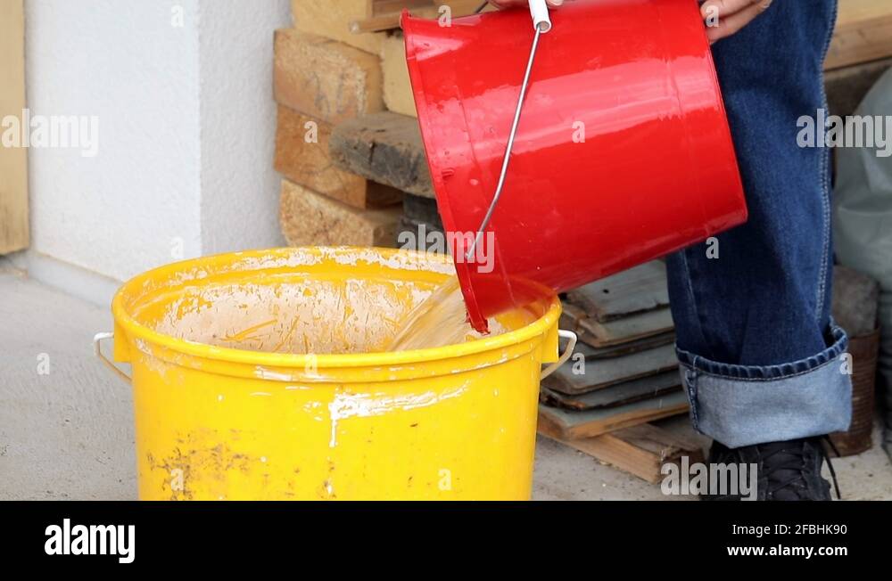 Builder Man Pouring Water Into Yellow Bucket On Construction Site Stock ...