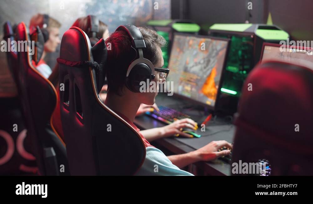 Young gamer plays a video game, side view, uses gaming mouse and ...