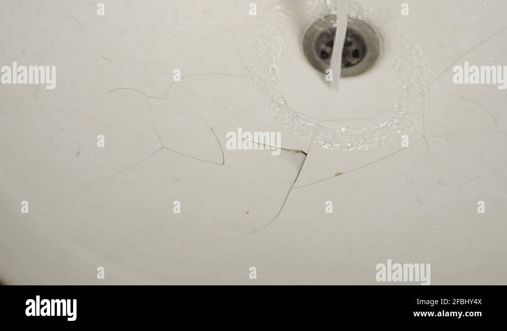 Close-up of water pouring from a tap into a broken cracked sink Stock ...