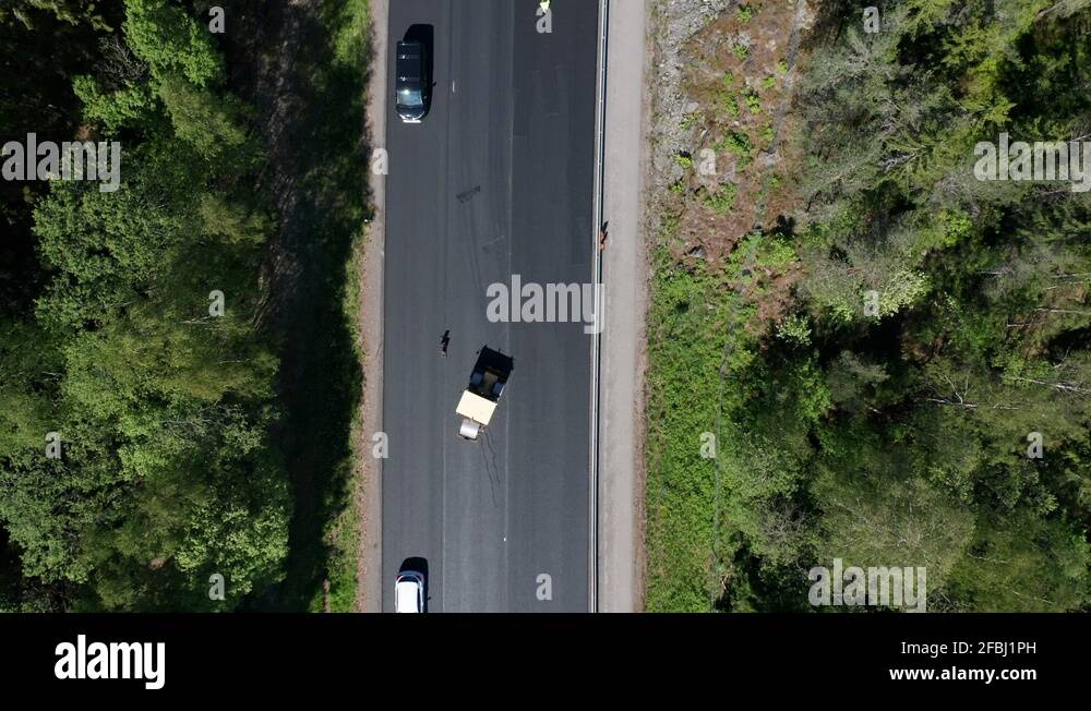 Reverse overhead drone footage of a country road under renovation with ...