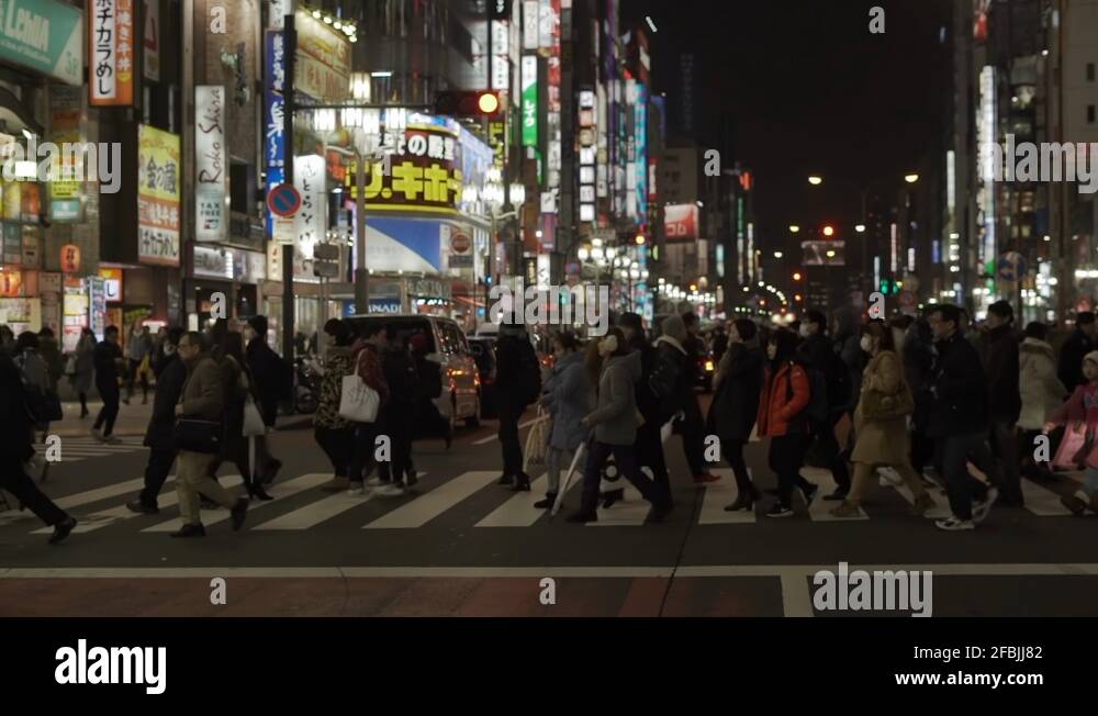 Masses of People Cross a Busy Tokyo Intersection at Night - Tokyo ...