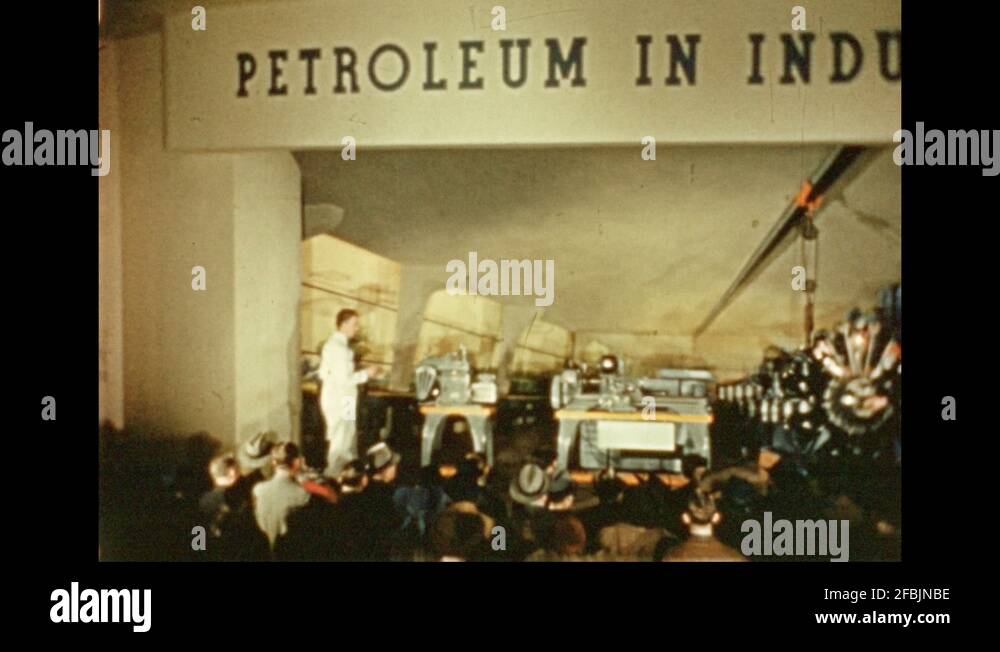 1930s: Crowd watches play. Stage is labeled "PETROLEUM IN INDUSTRY ...