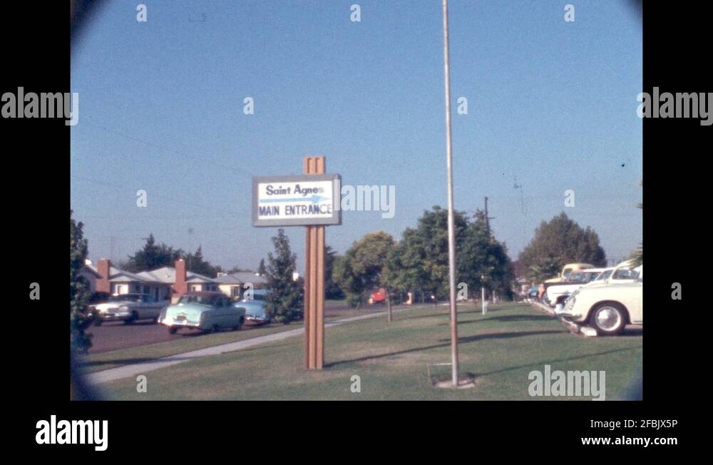 1960s: UNITED STATES: main entrance sign by hospital. Cars in car park ...