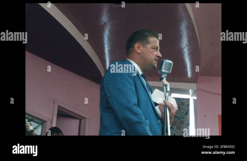 1960s: Man speaks into microphone on stage. Beauty pageant contestants ...